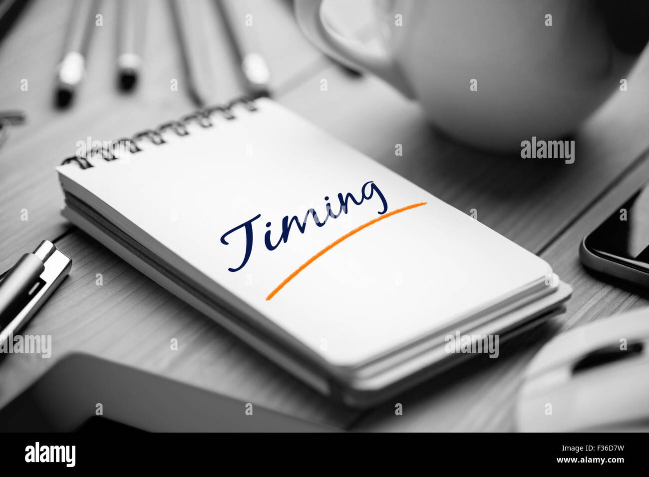 Timing against notepad on desk Stock Photo - Alamy