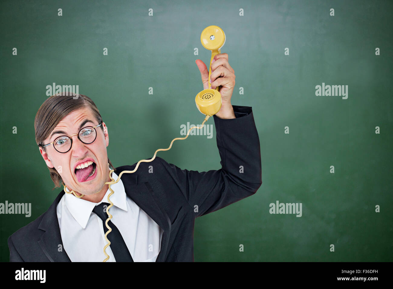 Composite image of geeky businessman being strangled by phone cord ...
