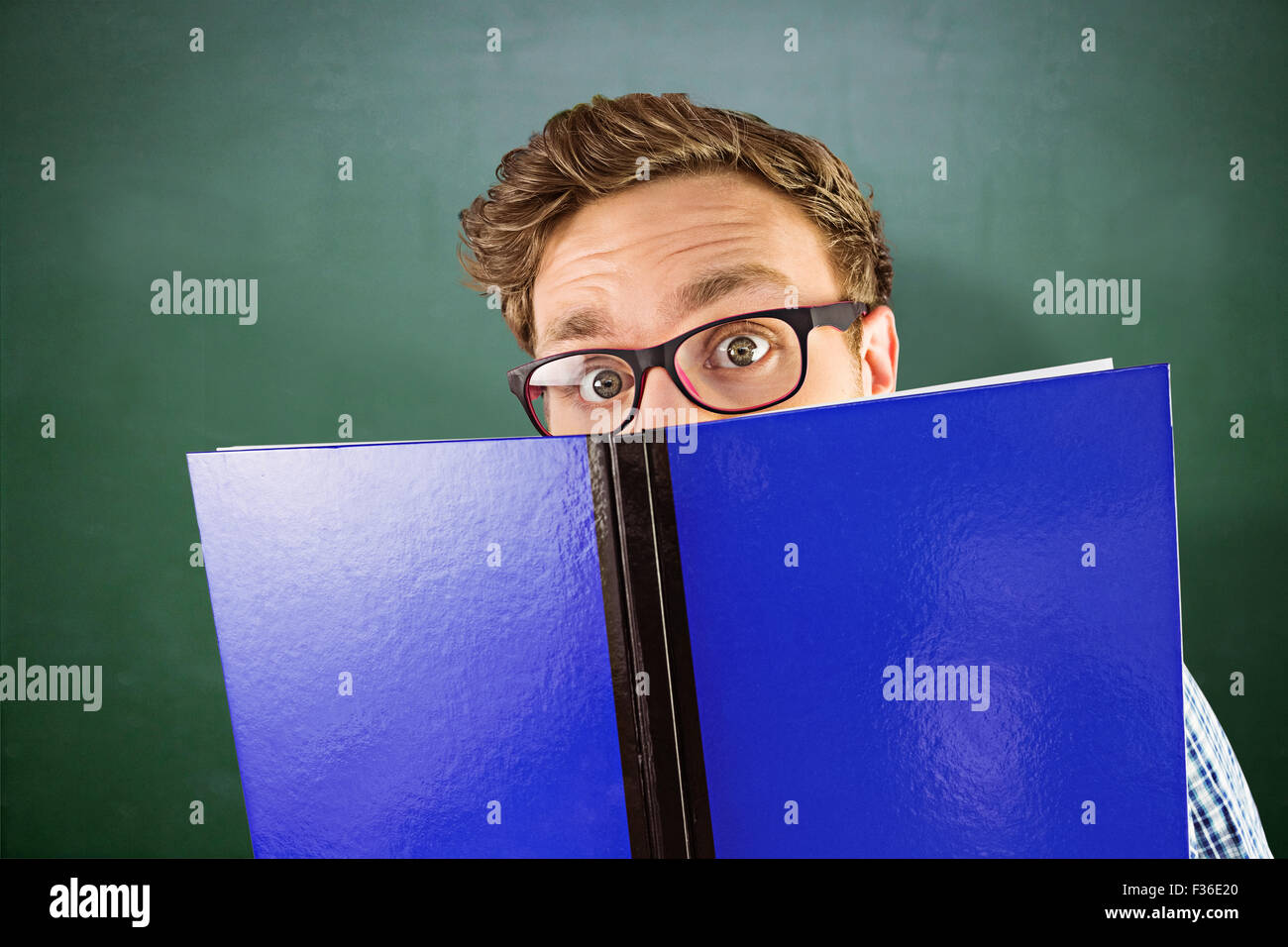 Composite image of geeky student reading a book Stock Photo - Alamy
