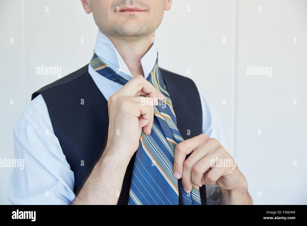 Businessman tying his tie Stock Photo - Alamy
