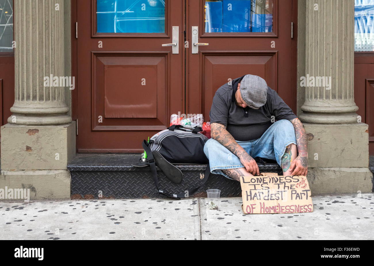 Homeless man with a handwritten sign half asleep on a New York City ...