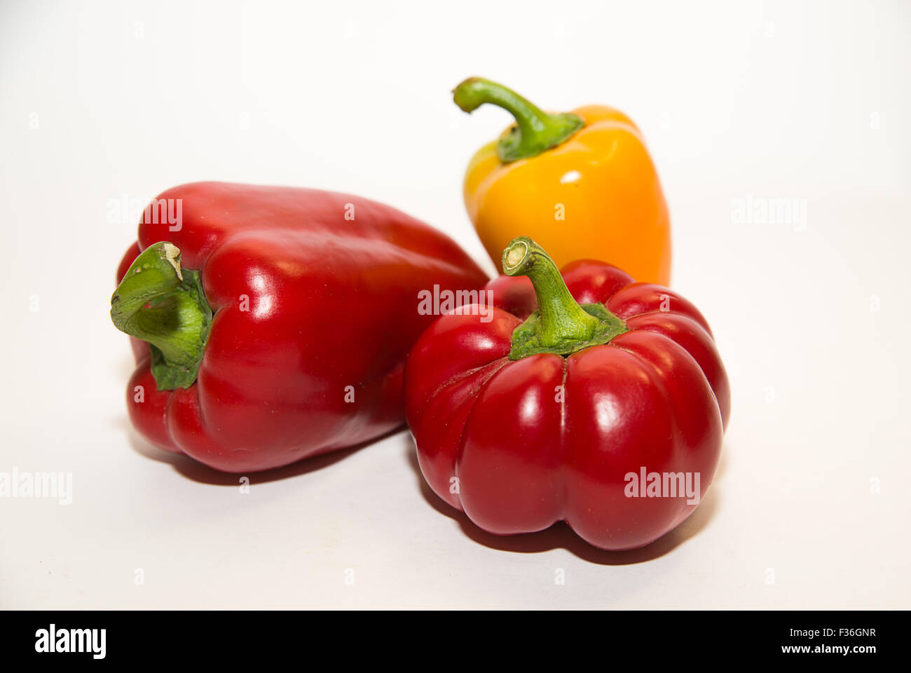 Three peppers on a white background Stock Photo - Alamy
