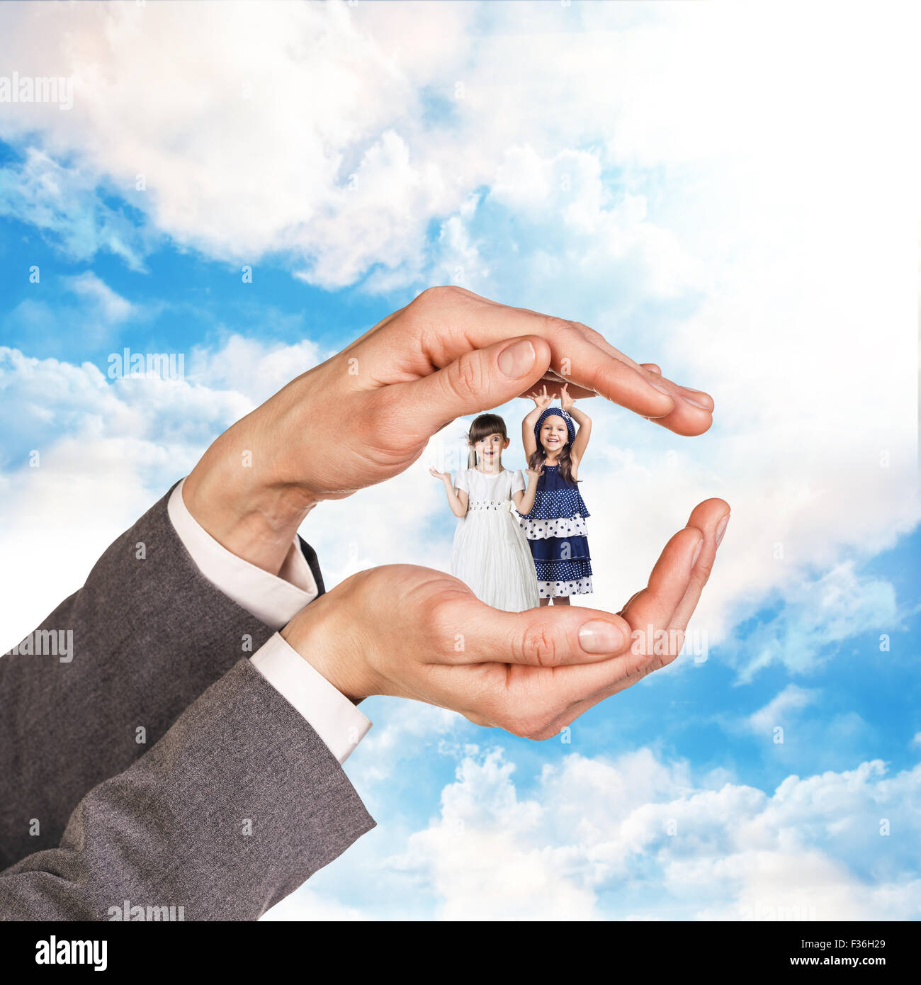 Children in big hands Stock Photo - Alamy