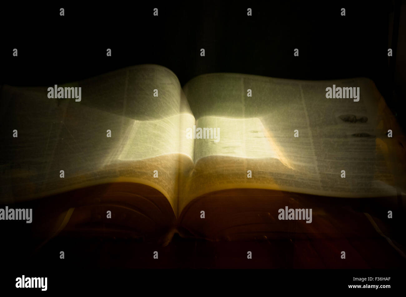 Glowing book of magic spells Stock Photo - Alamy