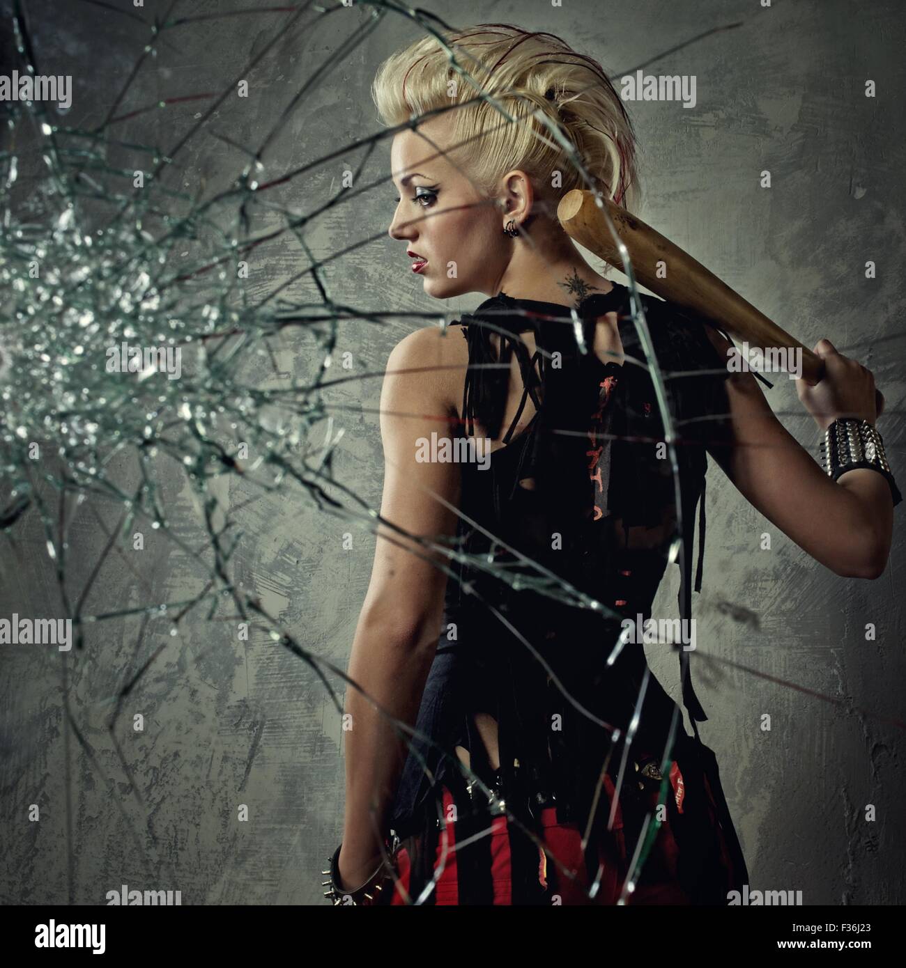 Punk girl with a bat behind broken glass Stock Photo - Alamy
