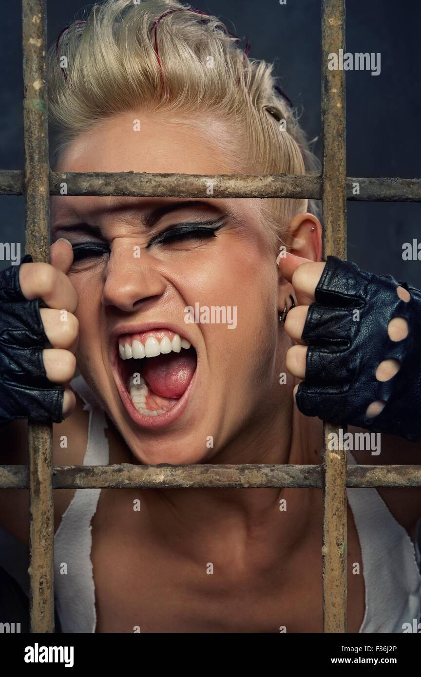 Punk girl screaming behind bars Stock Photo - Alamy