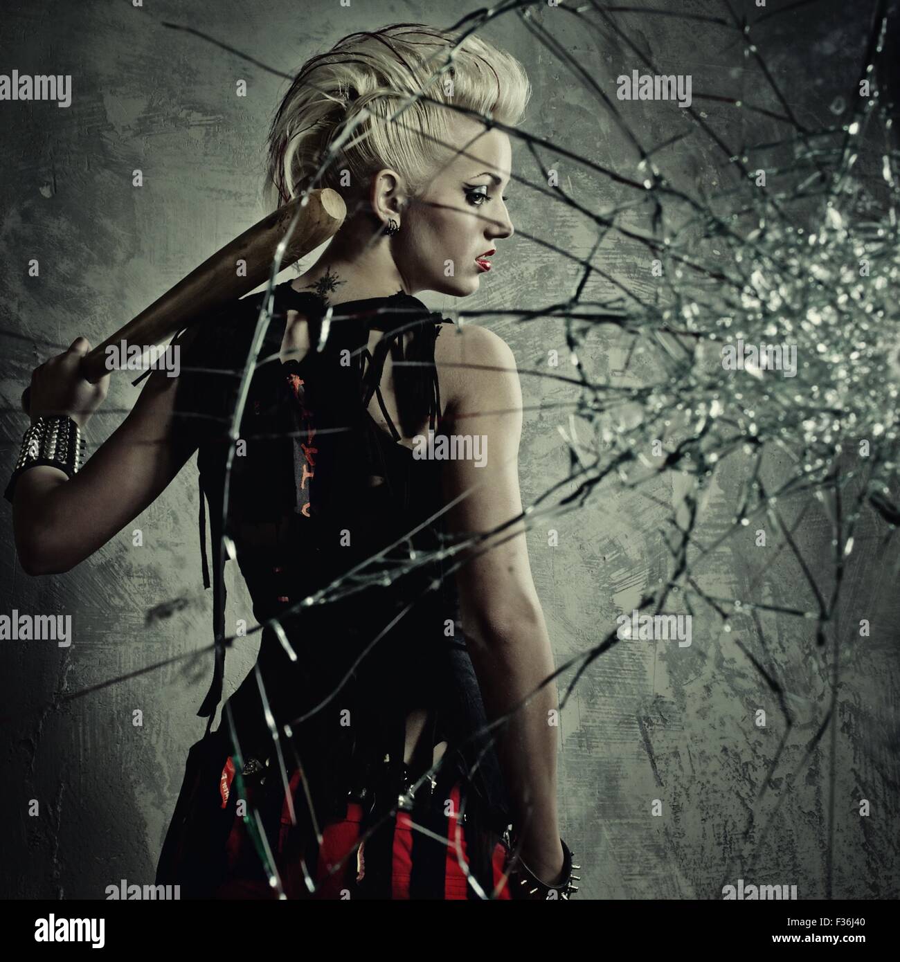 Punk girl with a bat behind broken glass Stock Photo - Alamy