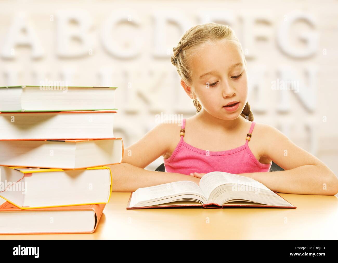 Little schoolgirl reading a book Stock Photo - Alamy