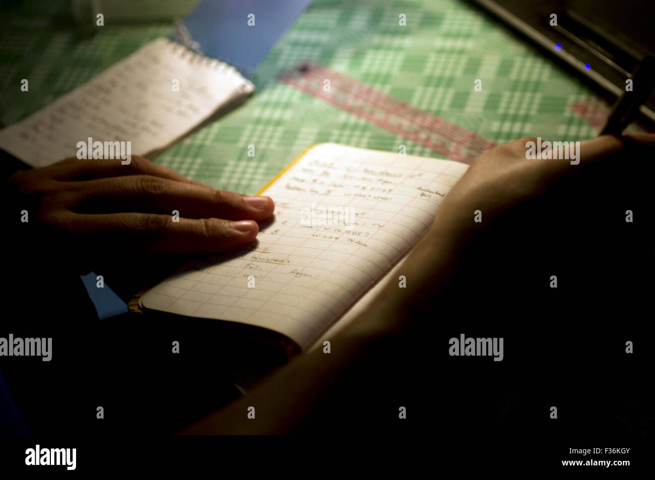 Hand and notebook with dramatic lighting Stock Photo - Alamy