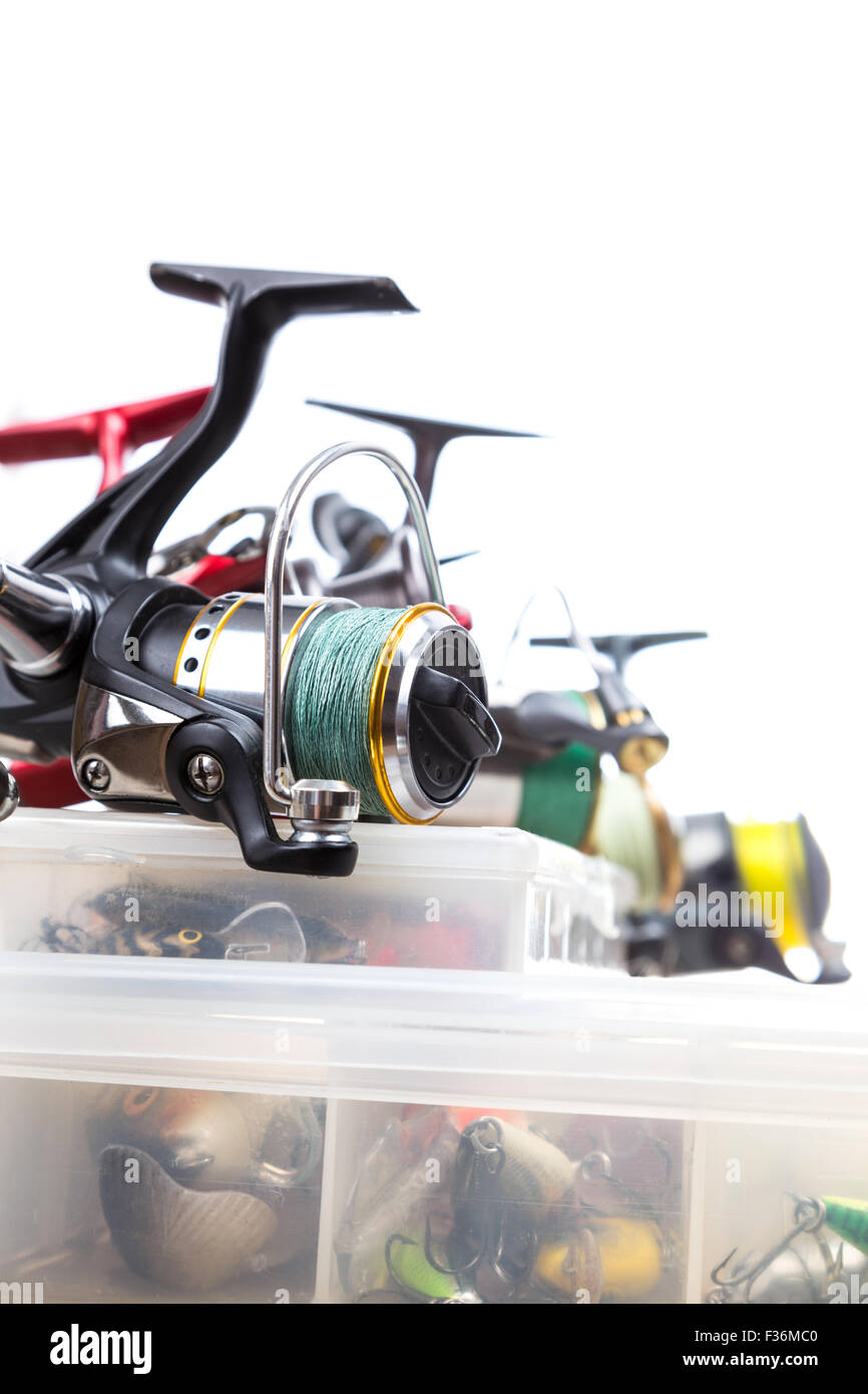 different fishing reels on storage boxes with fishing baits and lures ...