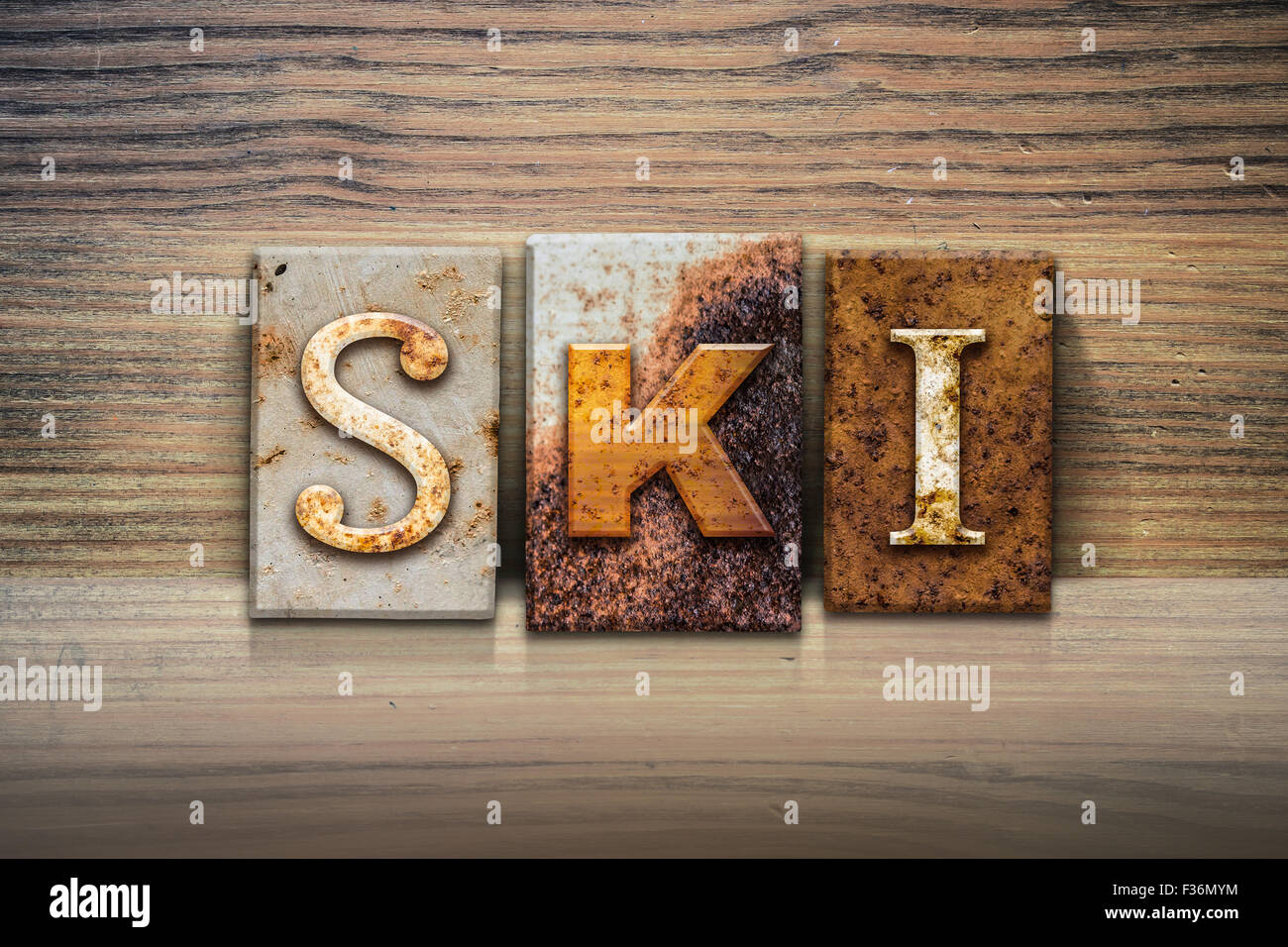 The word "SKI" written in rusty metal letterpress type sitting on a ...