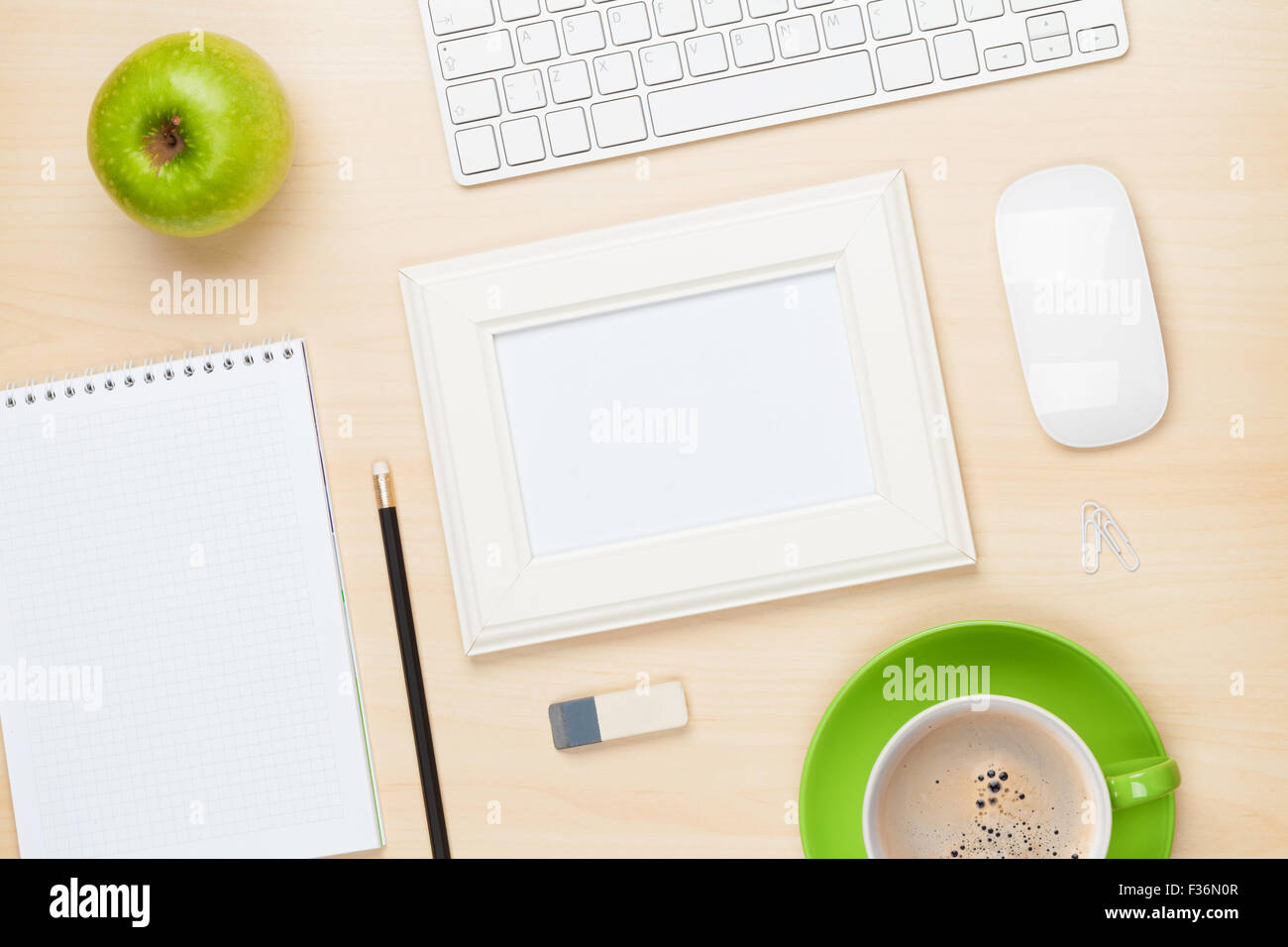 Photo frame on office table with notepad, computer and coffee cup. View ...