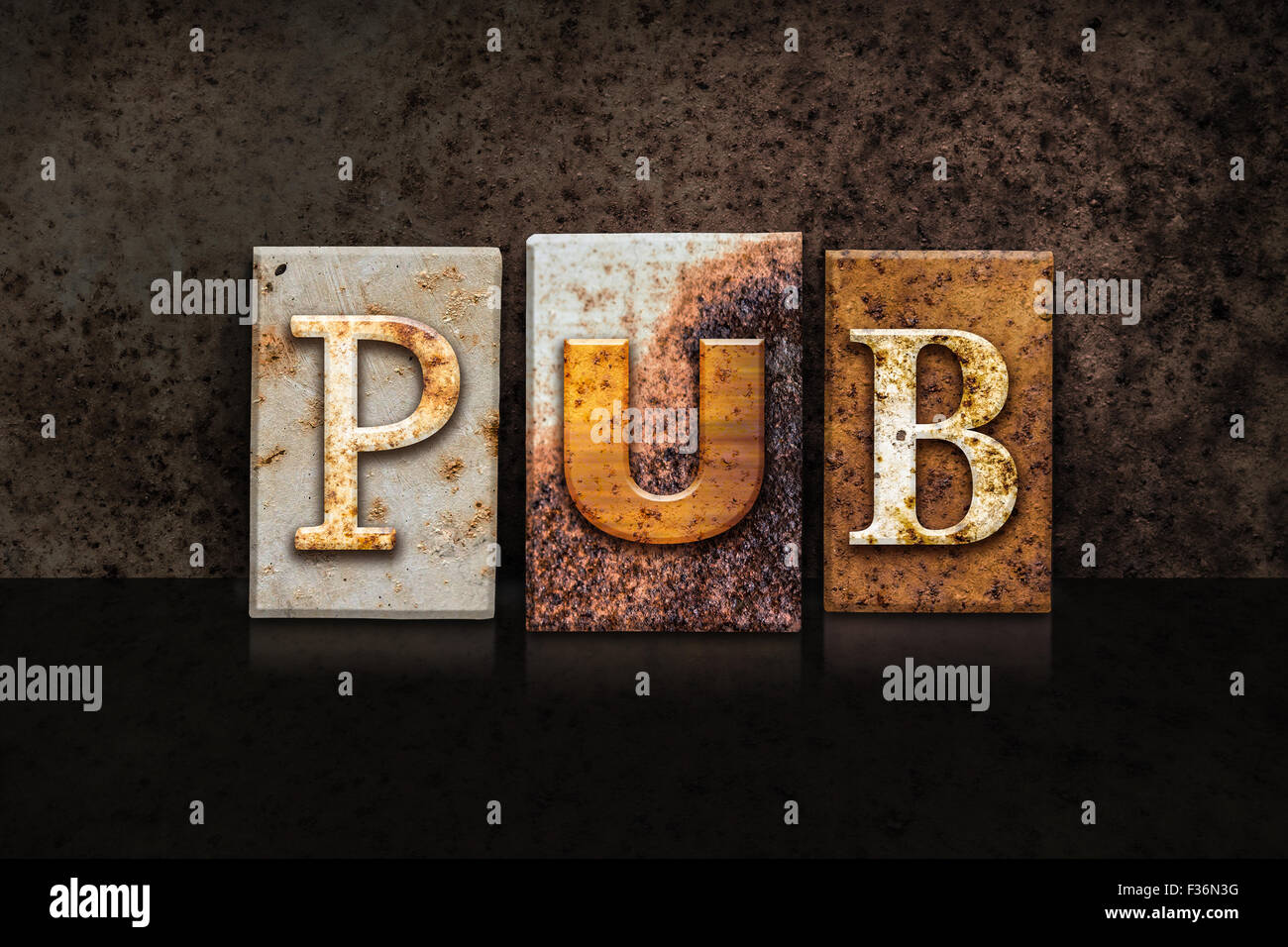 The word "PUB" written in rusty metal letterpress type on a dark ...