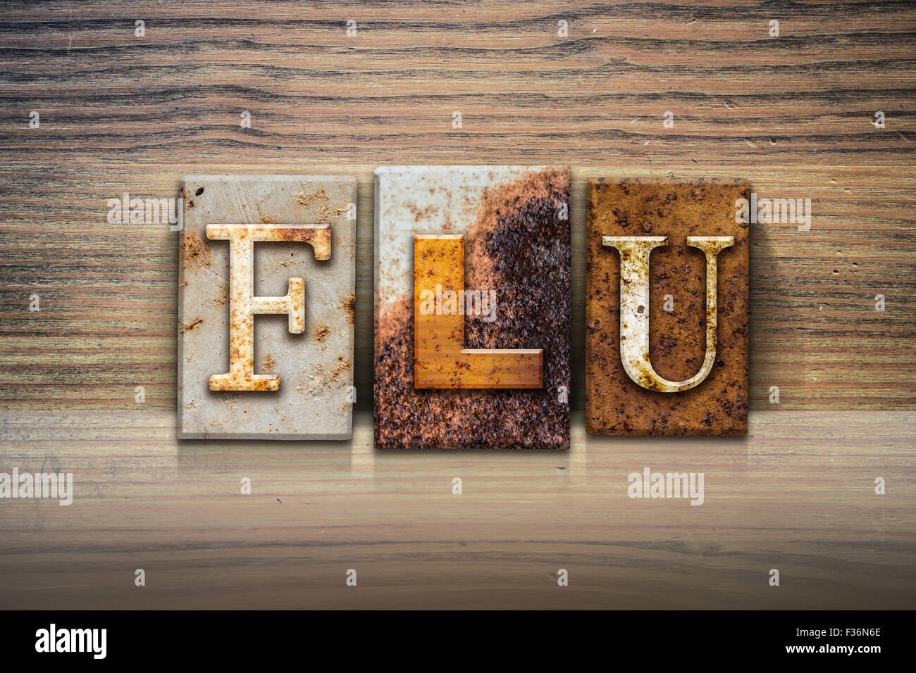 The word "FLU" written in rusty metal letterpress type sitting on a ...