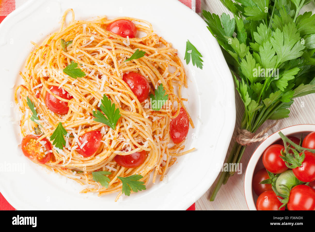 Spaghetti pasta with tomatoes and parsley on wooden table. Top view ...