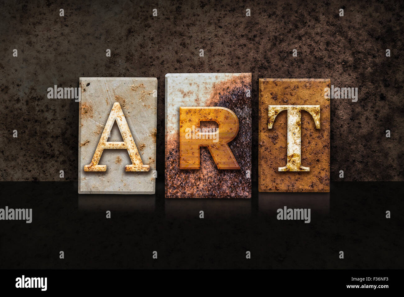 The word "ART" written in rusty metal letterpress type on a dark ...