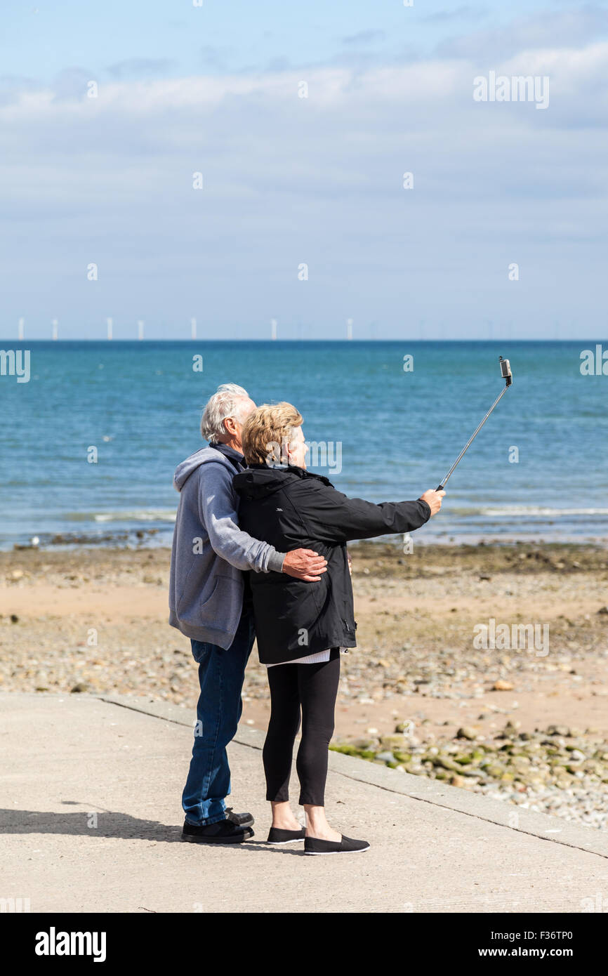 Middle Aged Man And Woman Taking Selfies Self Portrait Using A Selfie