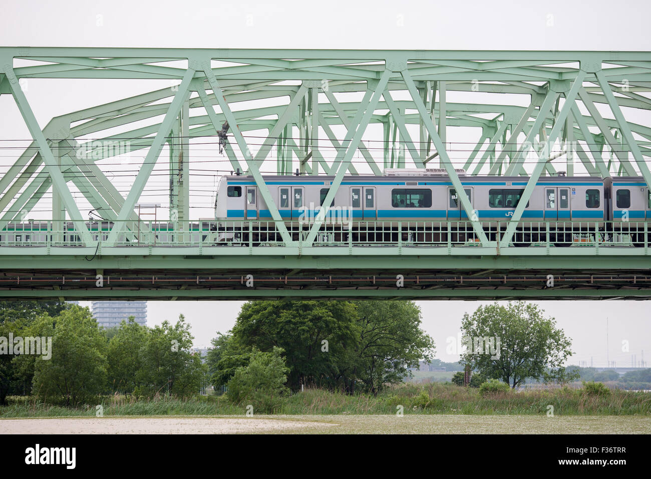 Silver and blue train on aqua colored bridge Stock Photo - Alamy