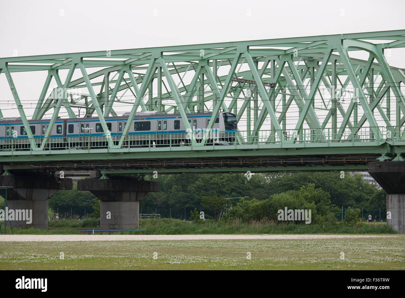 Silver and blue train on aqua colored bridge Stock Photo - Alamy