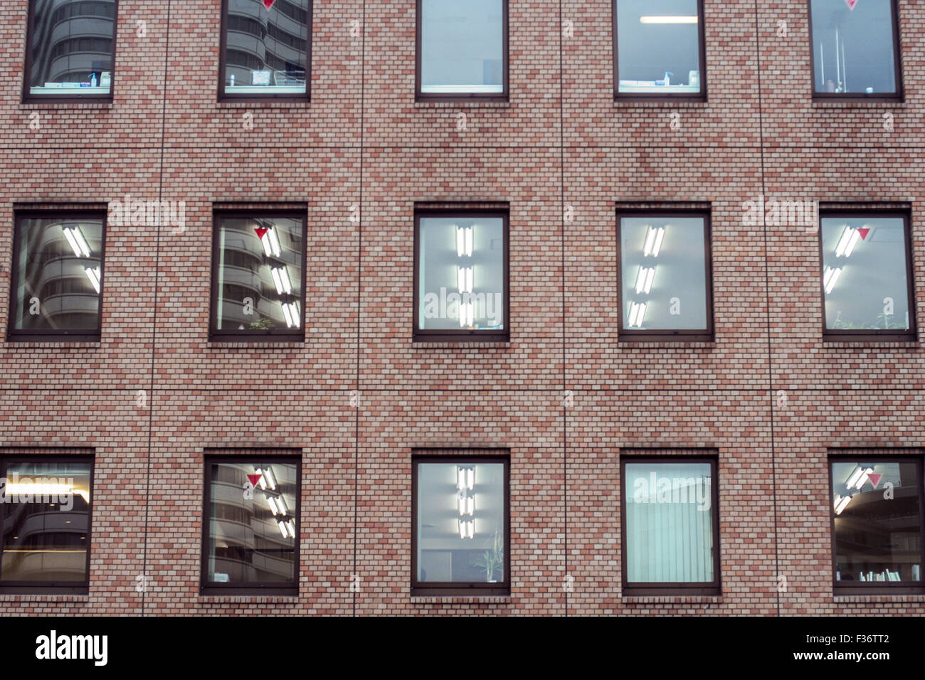 fluorescent lights viewable from glass windows and brick facade Stock ...