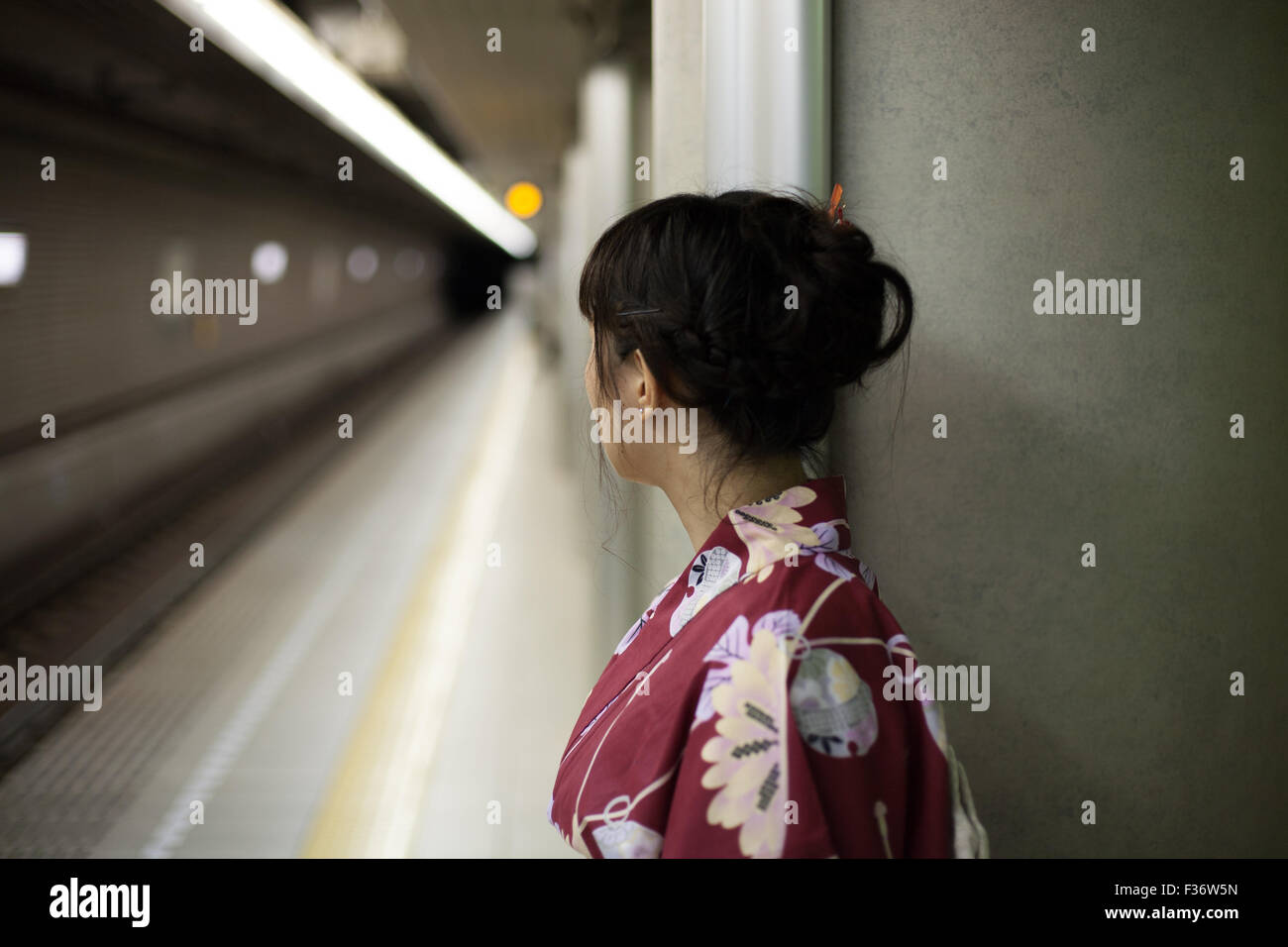 Girl in kimono waiting on subway platform Stock Photo - Alamy