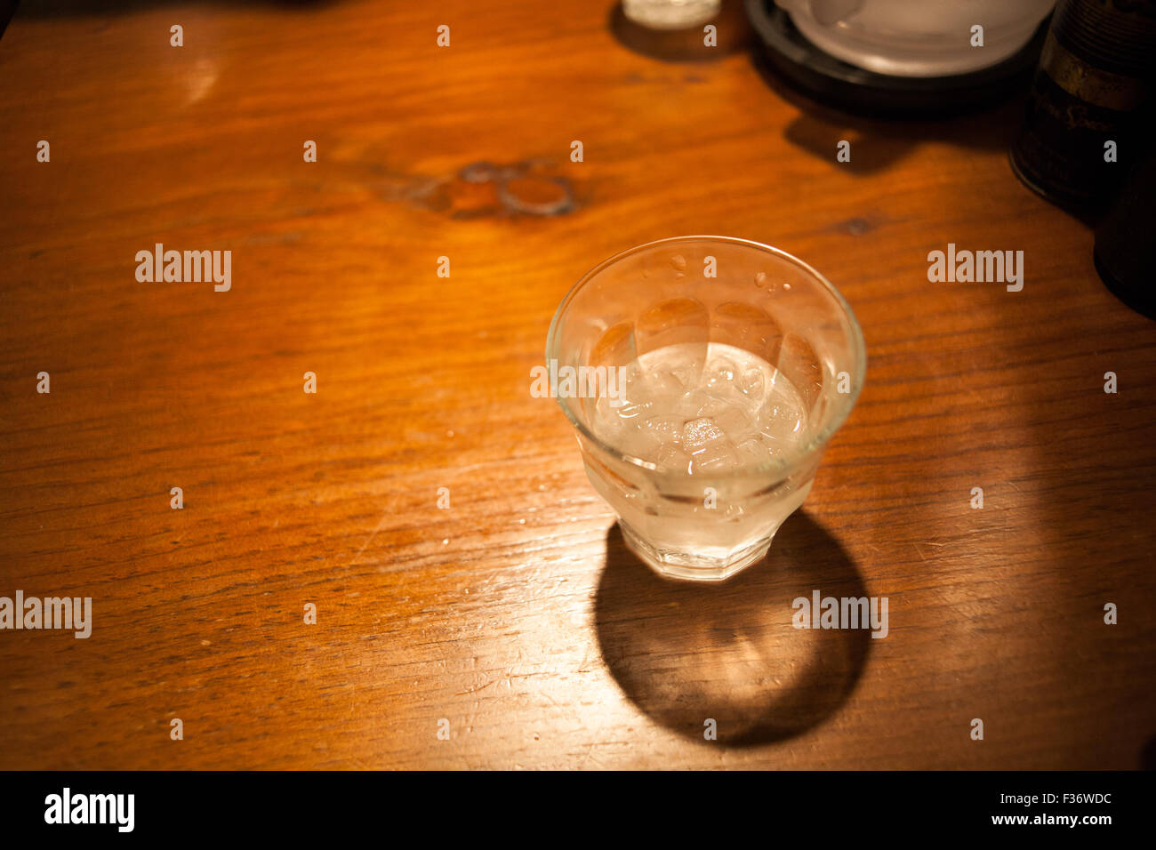 Glass of ice water on wooden table Stock Photo - Alamy