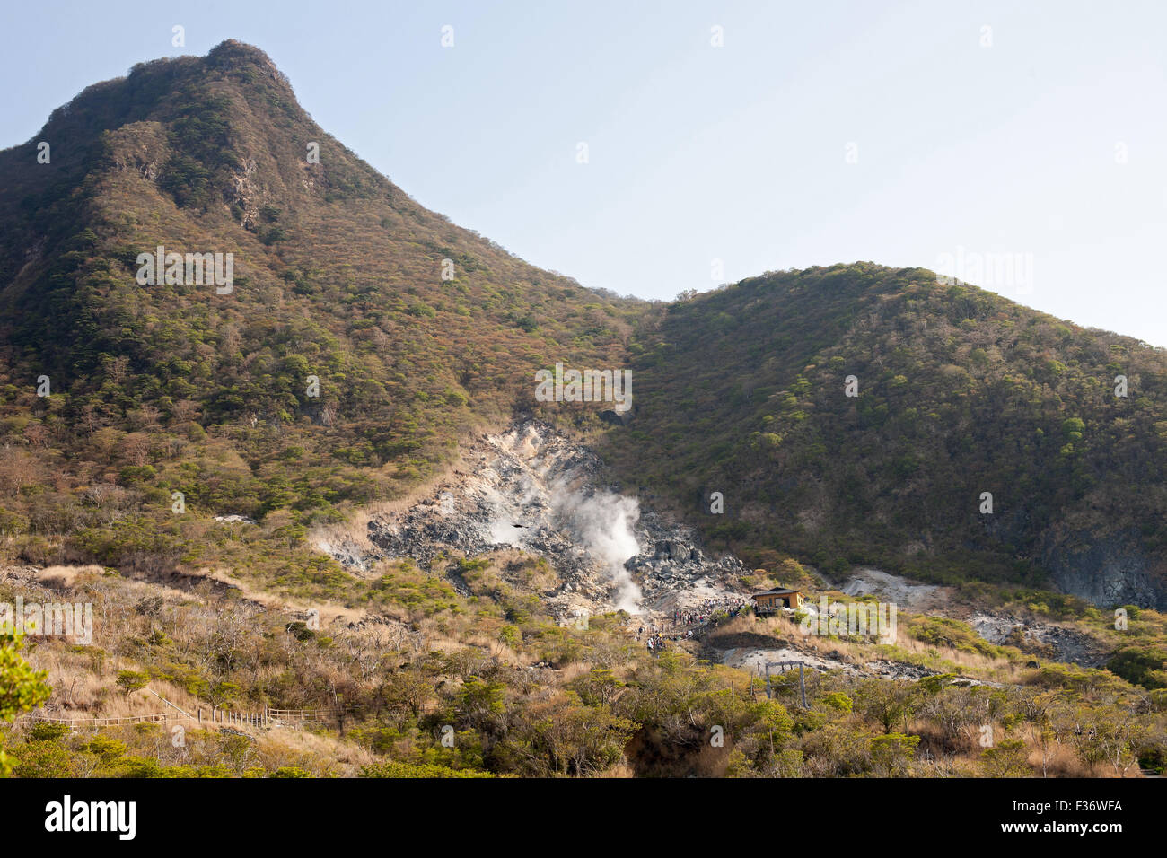 Natural hot spring steam rising from rocks surrounded by mountains ...