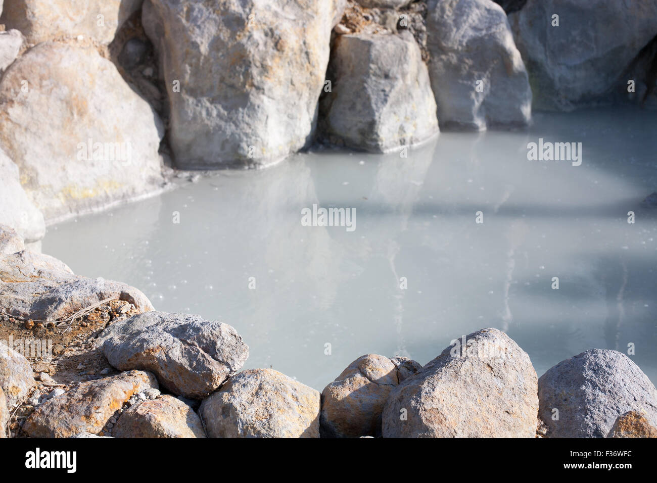 Small pool of gray water surrounded by rocks Stock Photo - Alamy