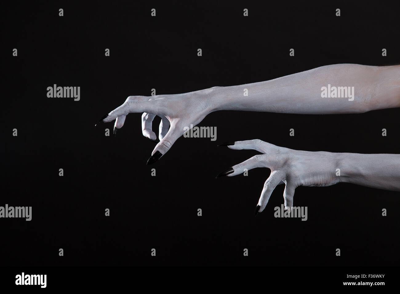 Scary Halloween white hands with black nails, body art Stock Photo - Alamy