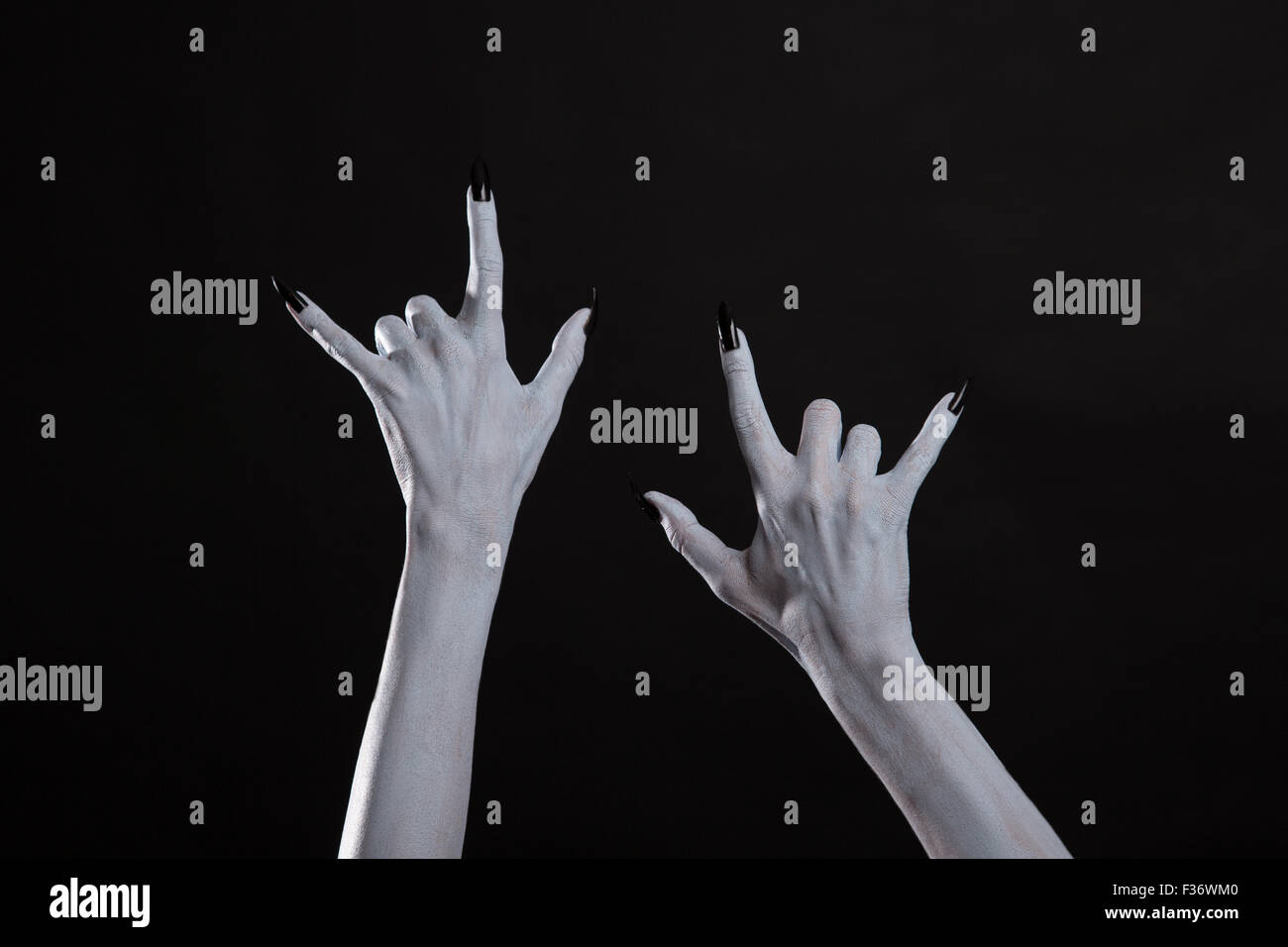 Pale monster hands showing heavy metal symbol, studio shot for ...