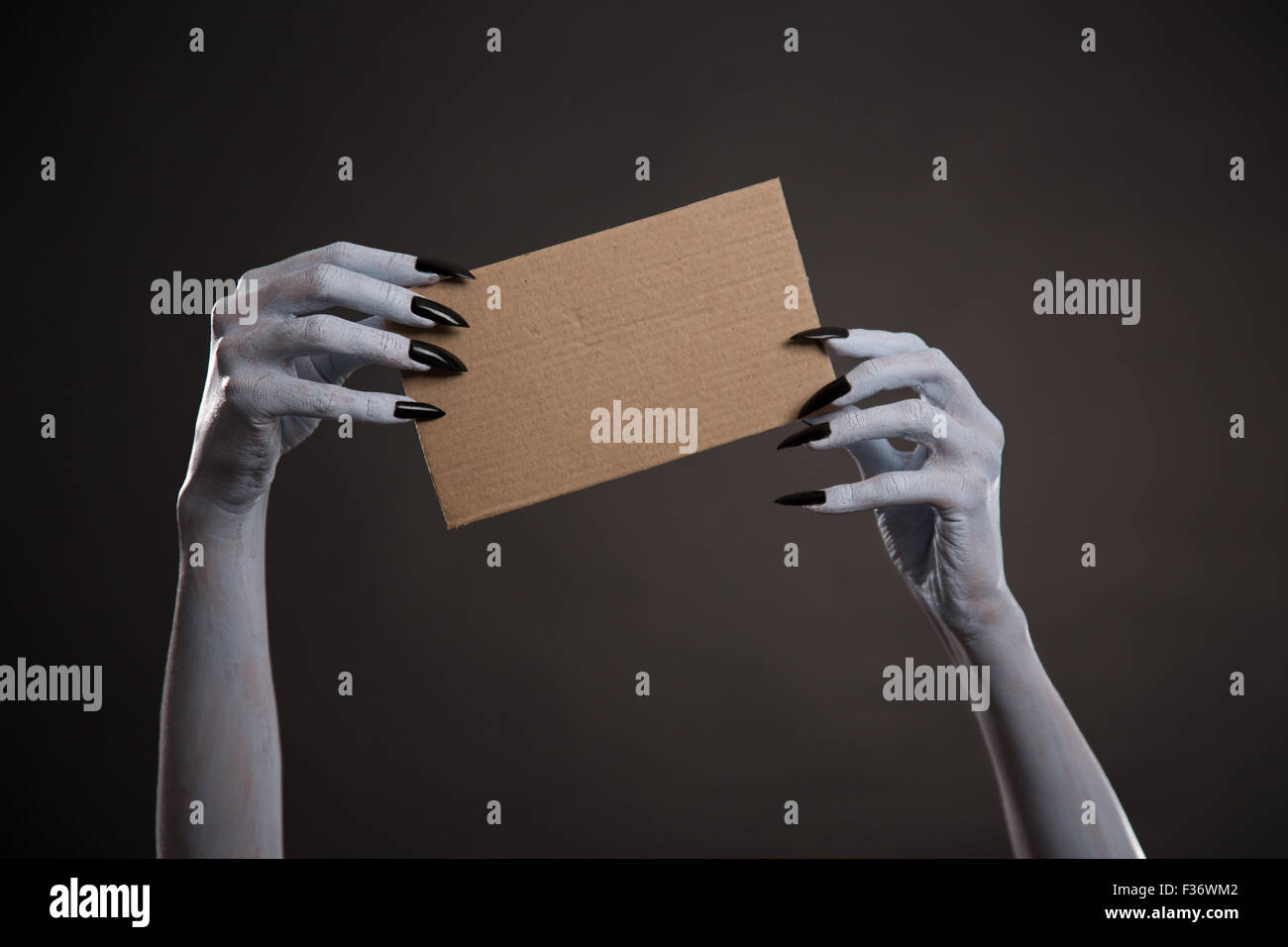 White witch hands with black nails holding blank cardboard, Halloween ...