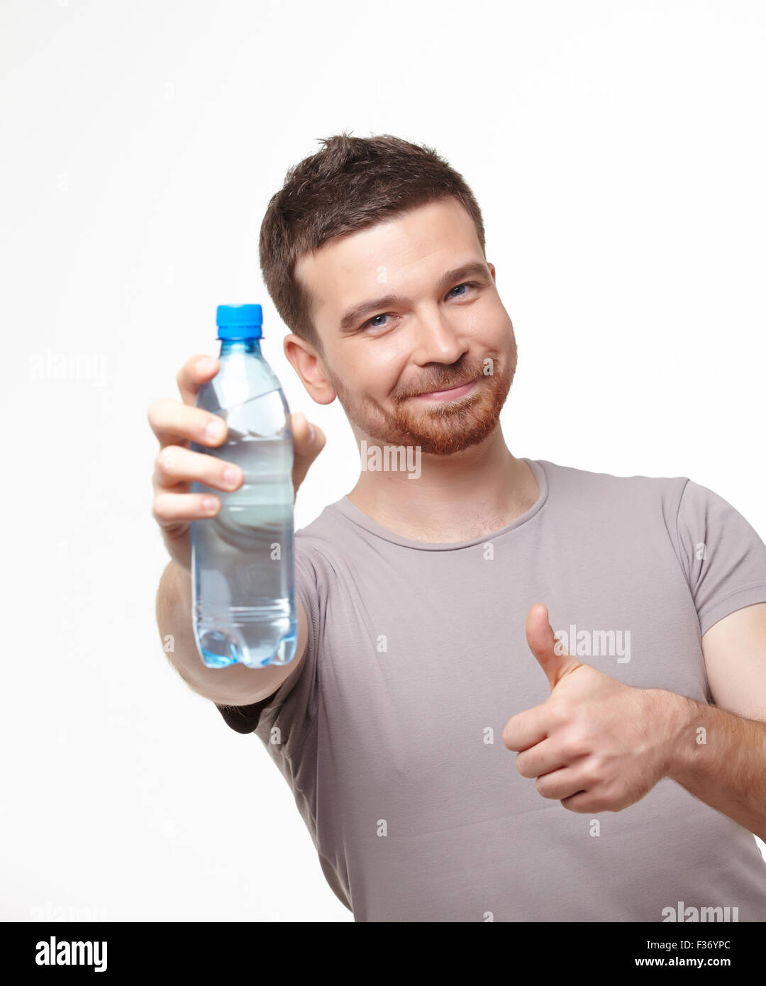 smiling young man showing water bottle Stock Photo - Alamy