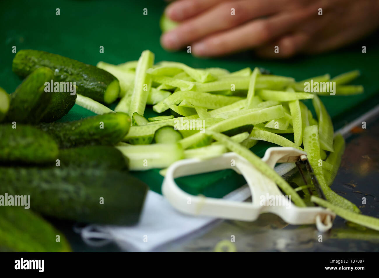 Cook cleans and cuts the cucumber Stock Photo - Alamy
