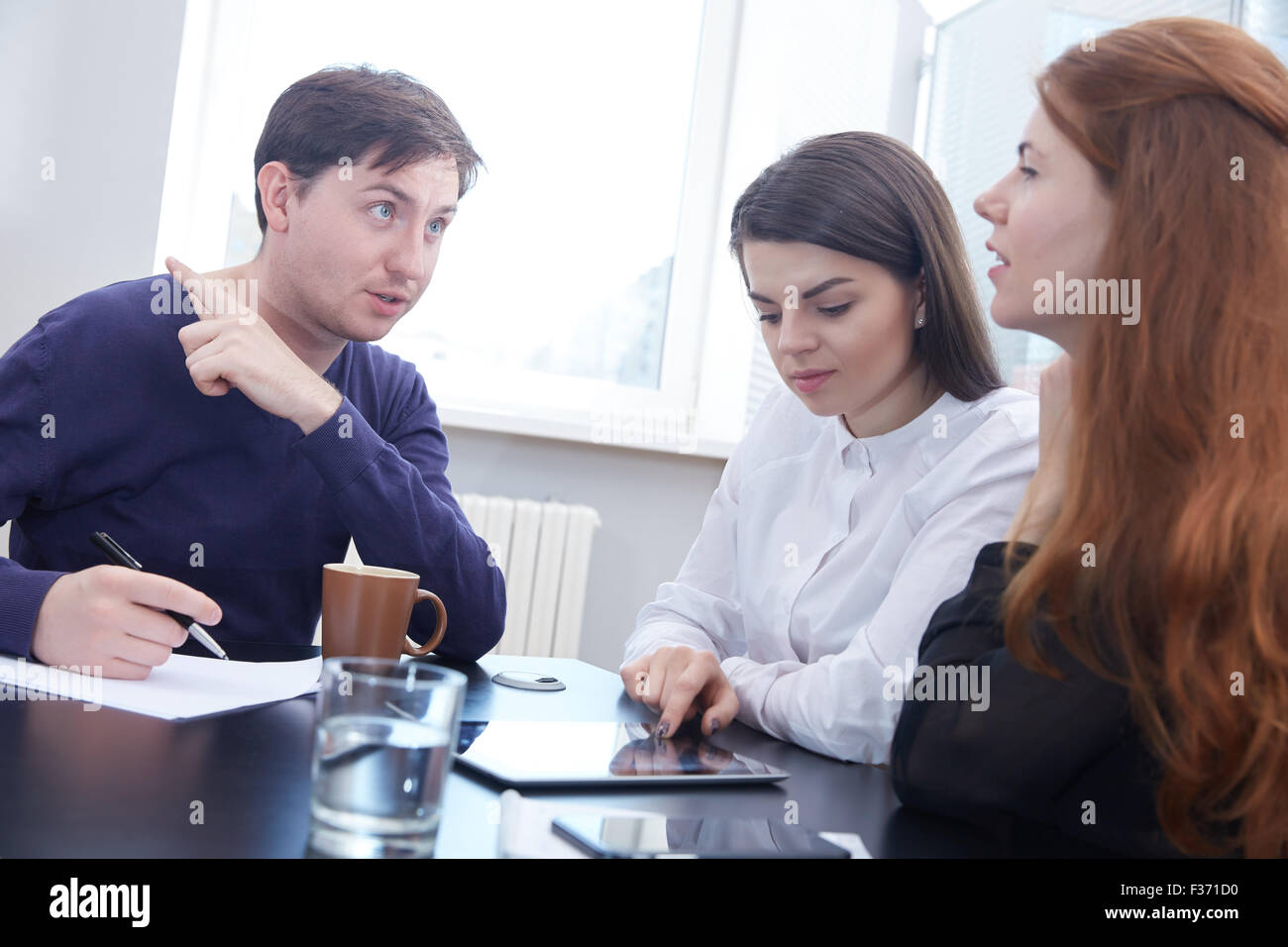 Three businessmen discussing something together Stock Photo - Alamy