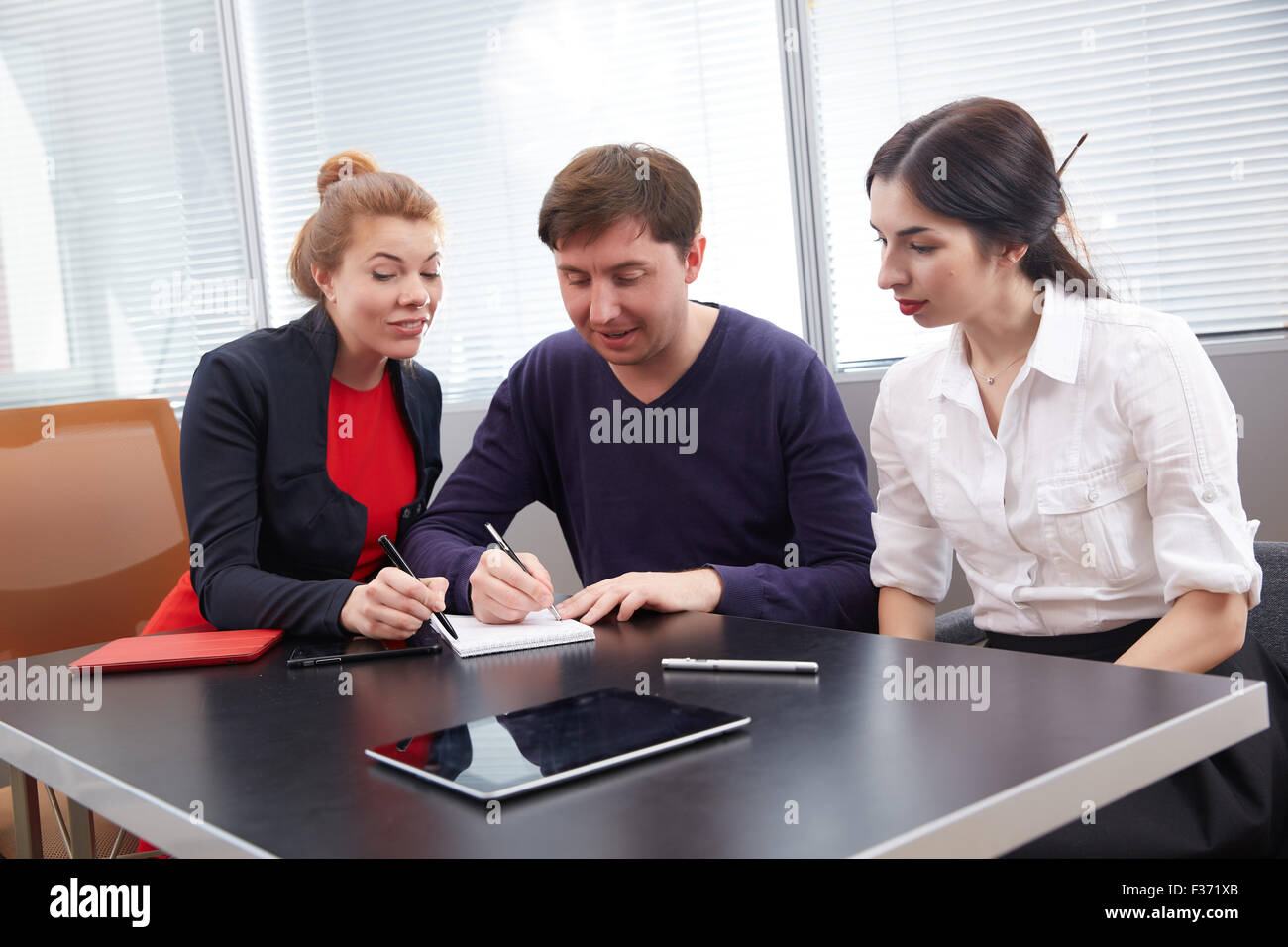 Three businessmen discussing something together Stock Photo - Alamy