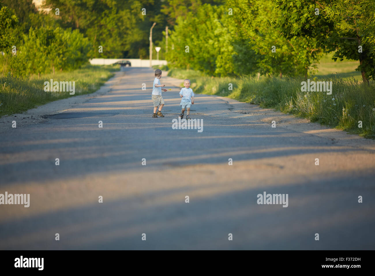 Two boys run on the road Stock Photo - Alamy