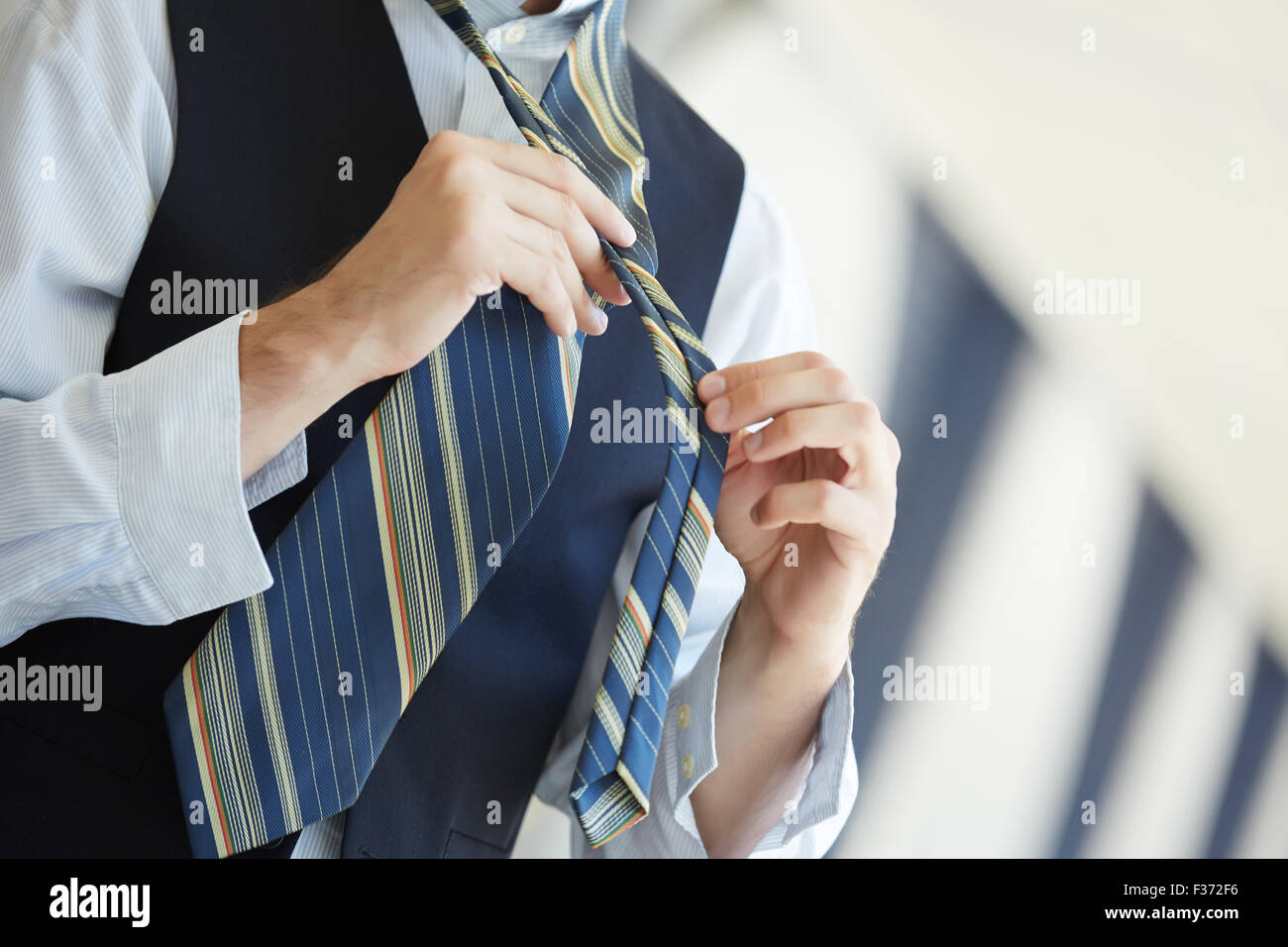 Businessman tying his tie Stock Photo - Alamy