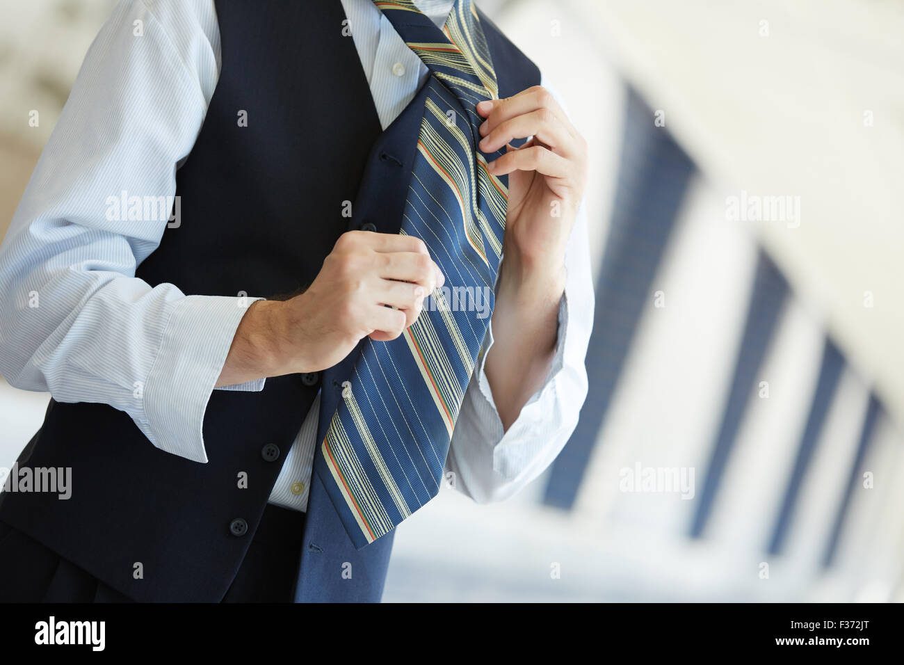 Businessman tying his tie Stock Photo - Alamy