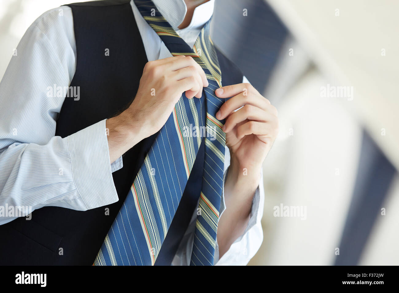 Businessman tying his tie Stock Photo - Alamy