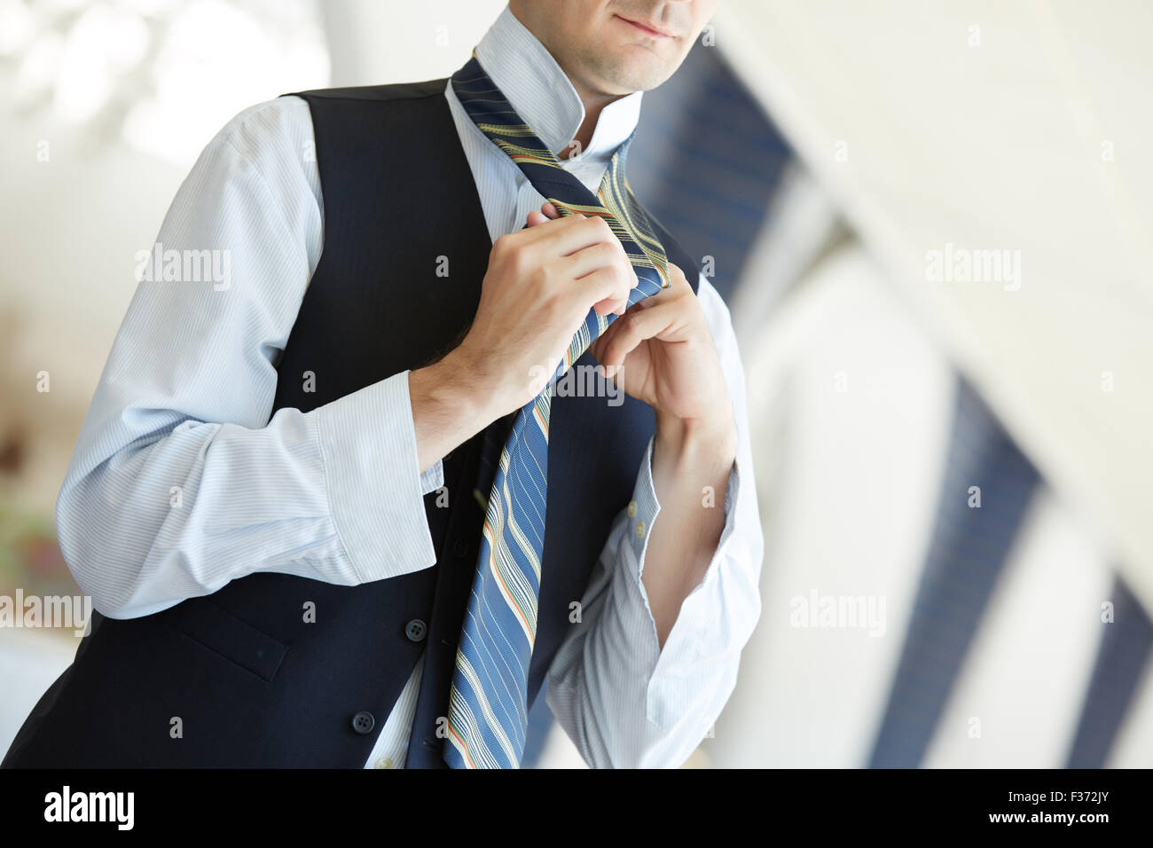Businessman tying his tie Stock Photo - Alamy