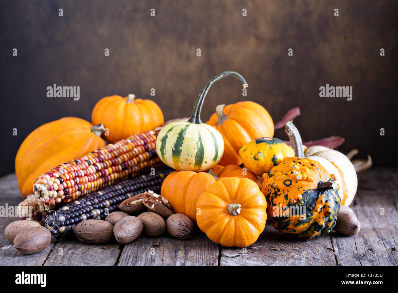 Pumpkins, indian corn and variety of squash on a rustic table Stock ...