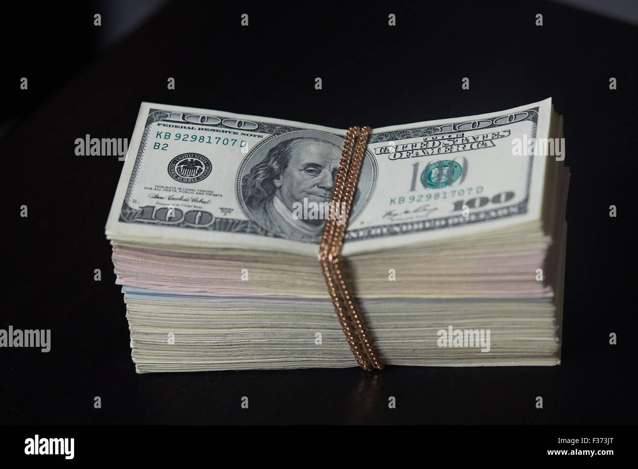 a bundle of money tied with gold chain Stock Photo - Alamy