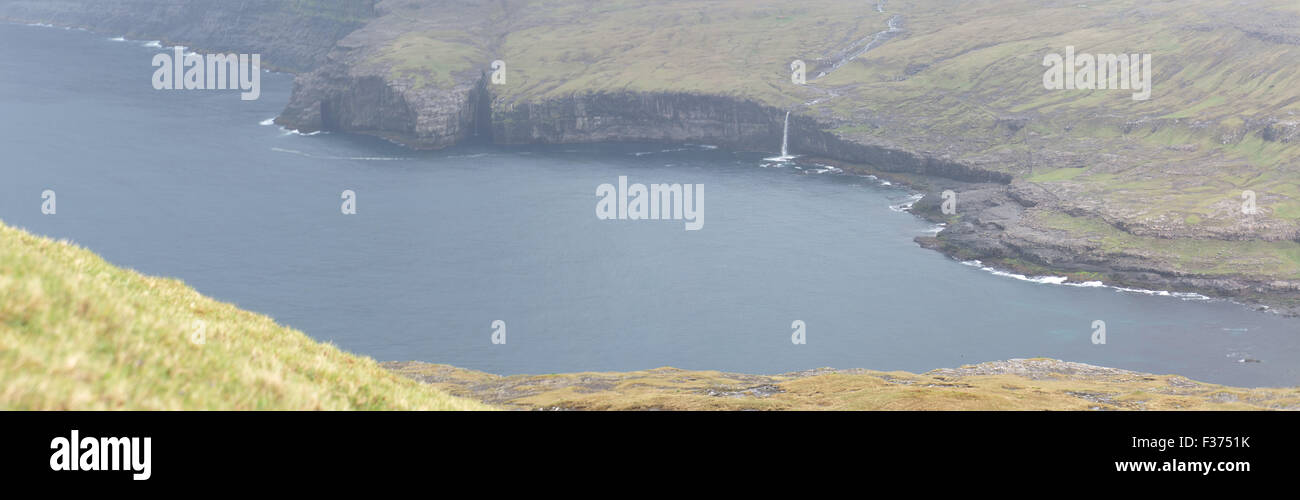 Typical landscape on the Faroe Islands, with ocean, green grass and ...