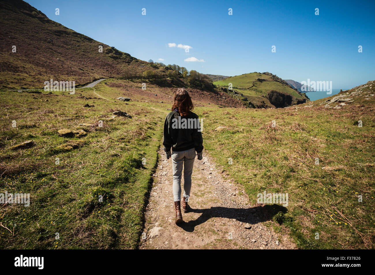 Young woman is walking along a path in the mountains Stock Photo - Alamy