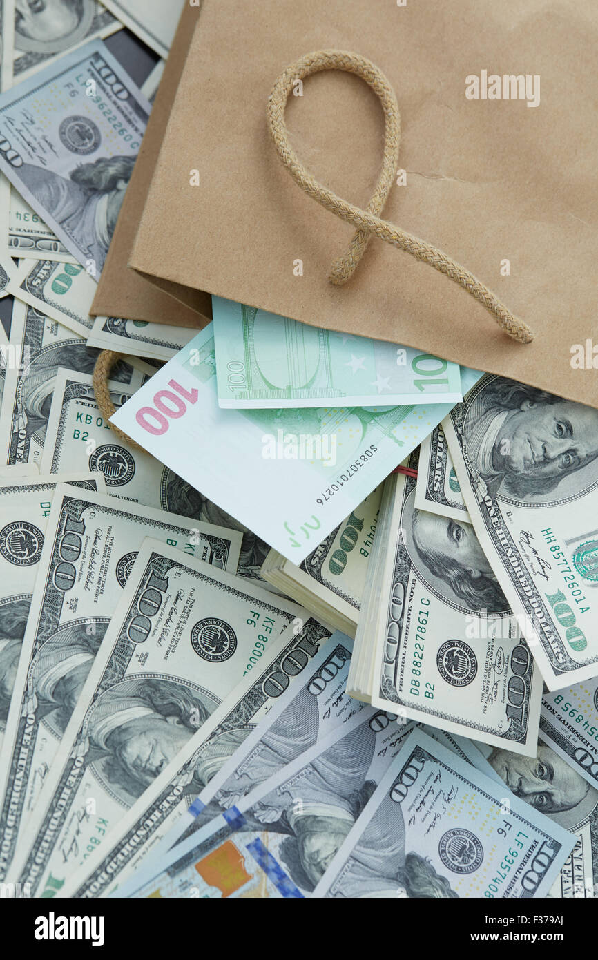 a lot of money out of a paper bag. dollars and euros Stock Photo - Alamy