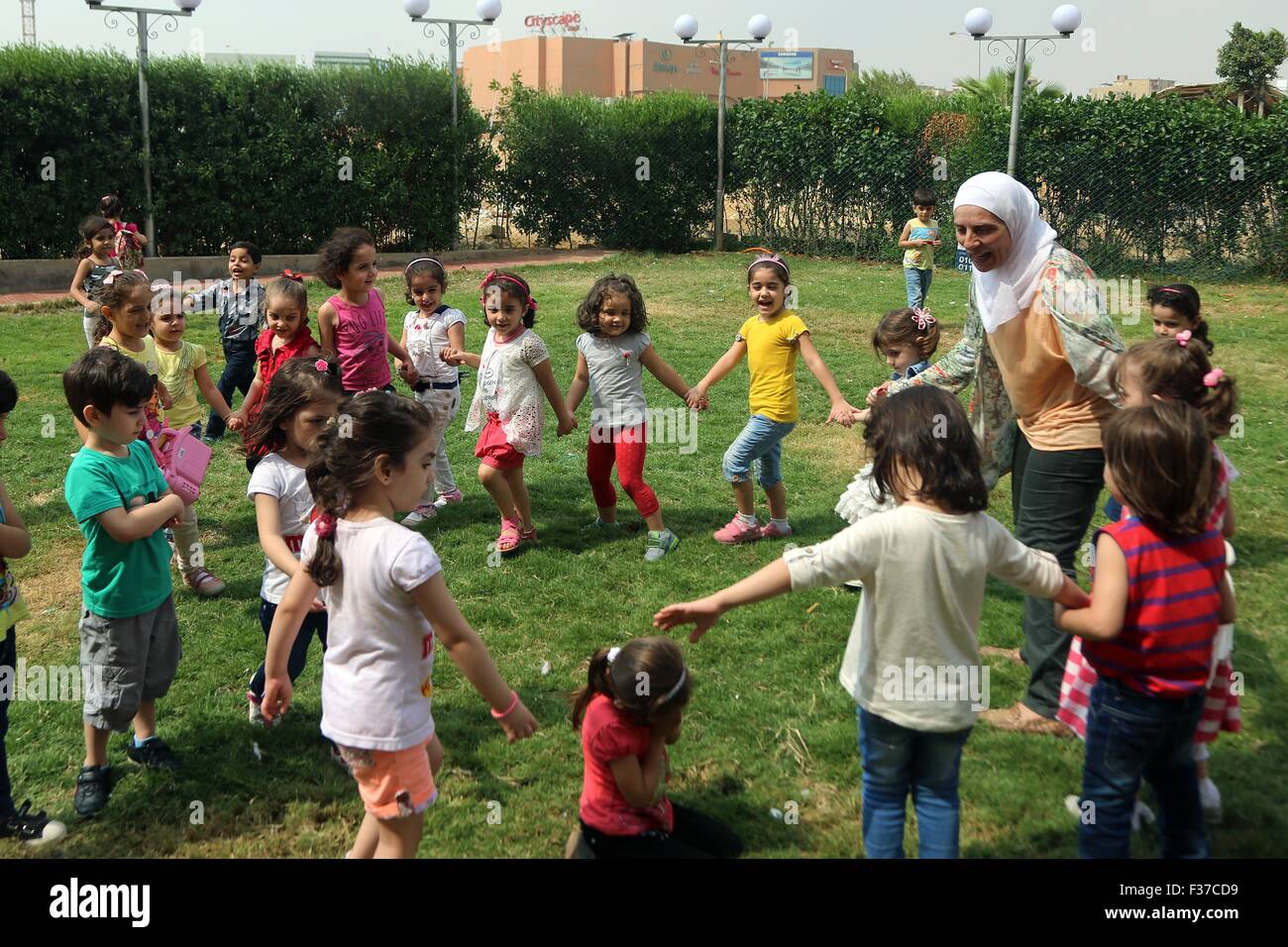 Cairo, Egypt. 30th Sep, 2015. Syrian kids have fun with their teacher ...