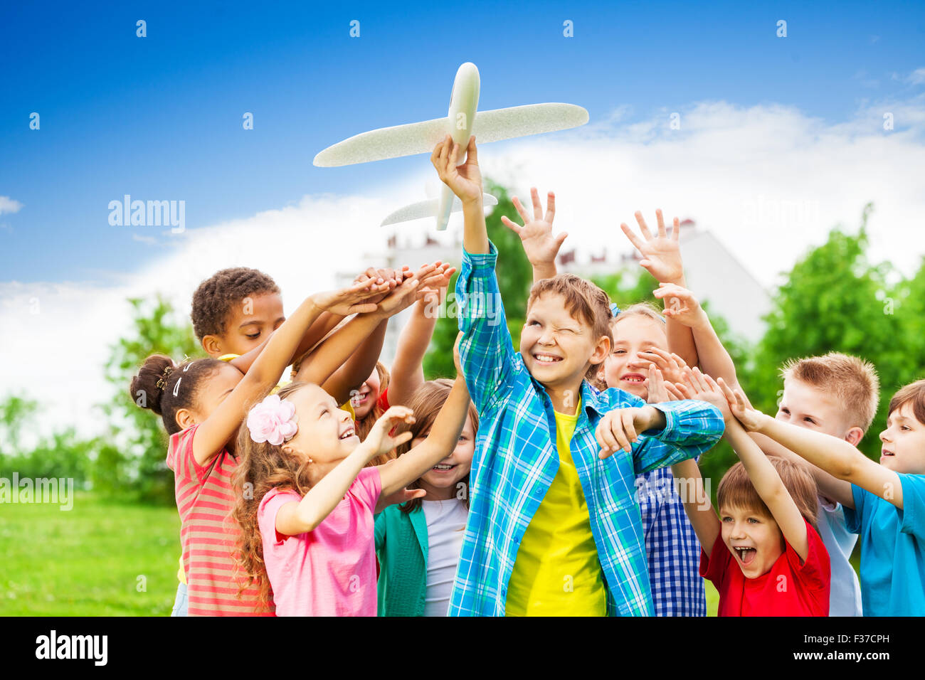 Children reaching after big white airplane toy Stock Photo - Alamy
