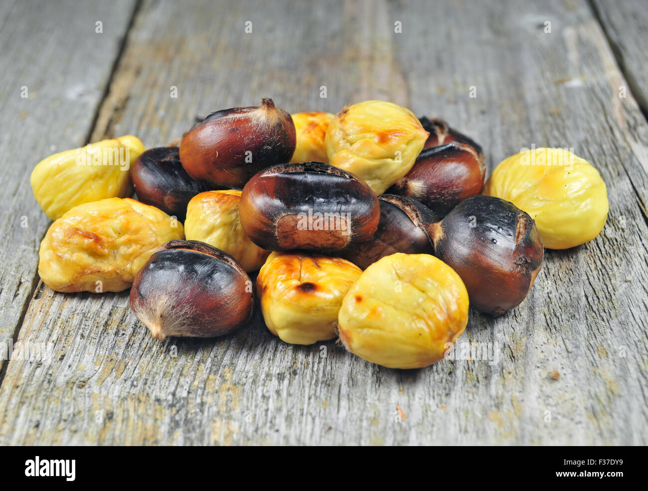 Close up photo of roasted chestnuts on a wooden table Stock Photo - Alamy