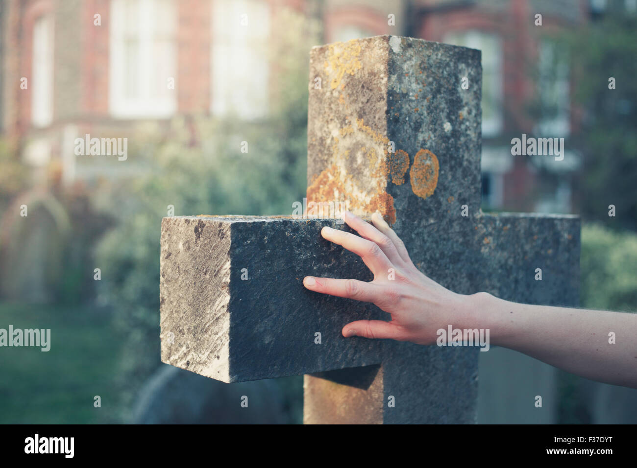 A woman's hand is touching a gravestone at sunset Stock Photo - Alamy