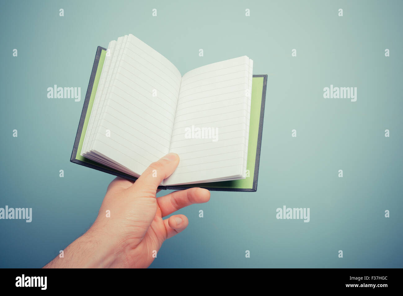 A hand is holding a small notebook Stock Photo - Alamy